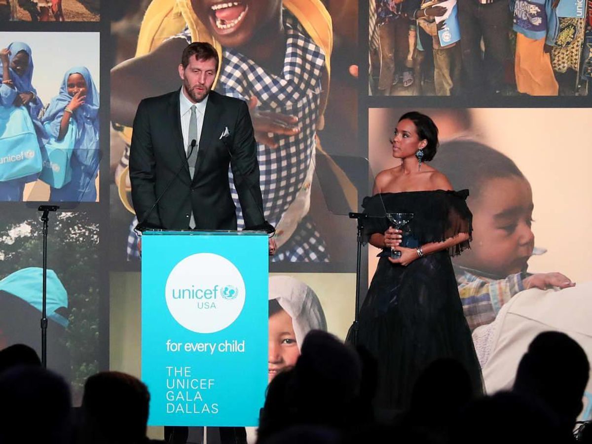 Dirk Nowitzki addresses the audience as wife Jessica looks on ...