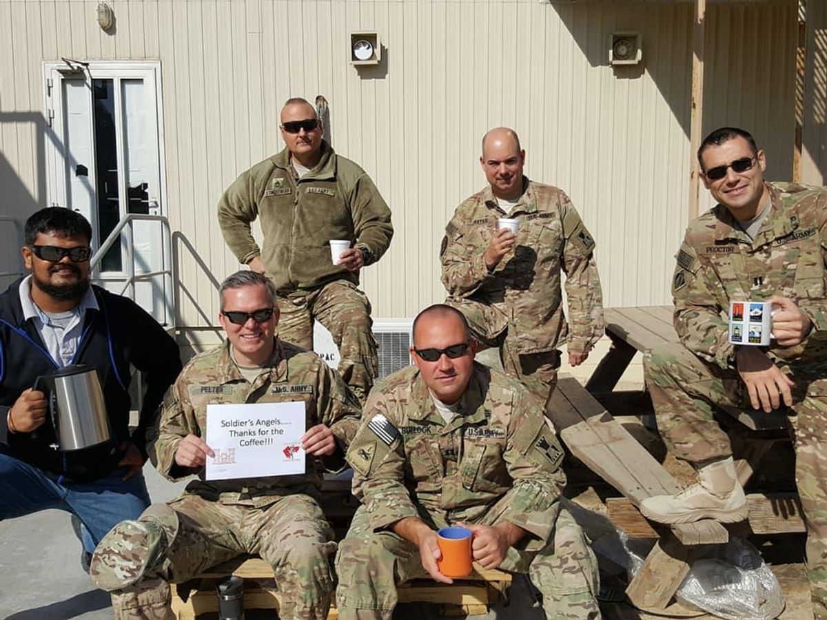Deployed service members posing with their coffee for a photo ...